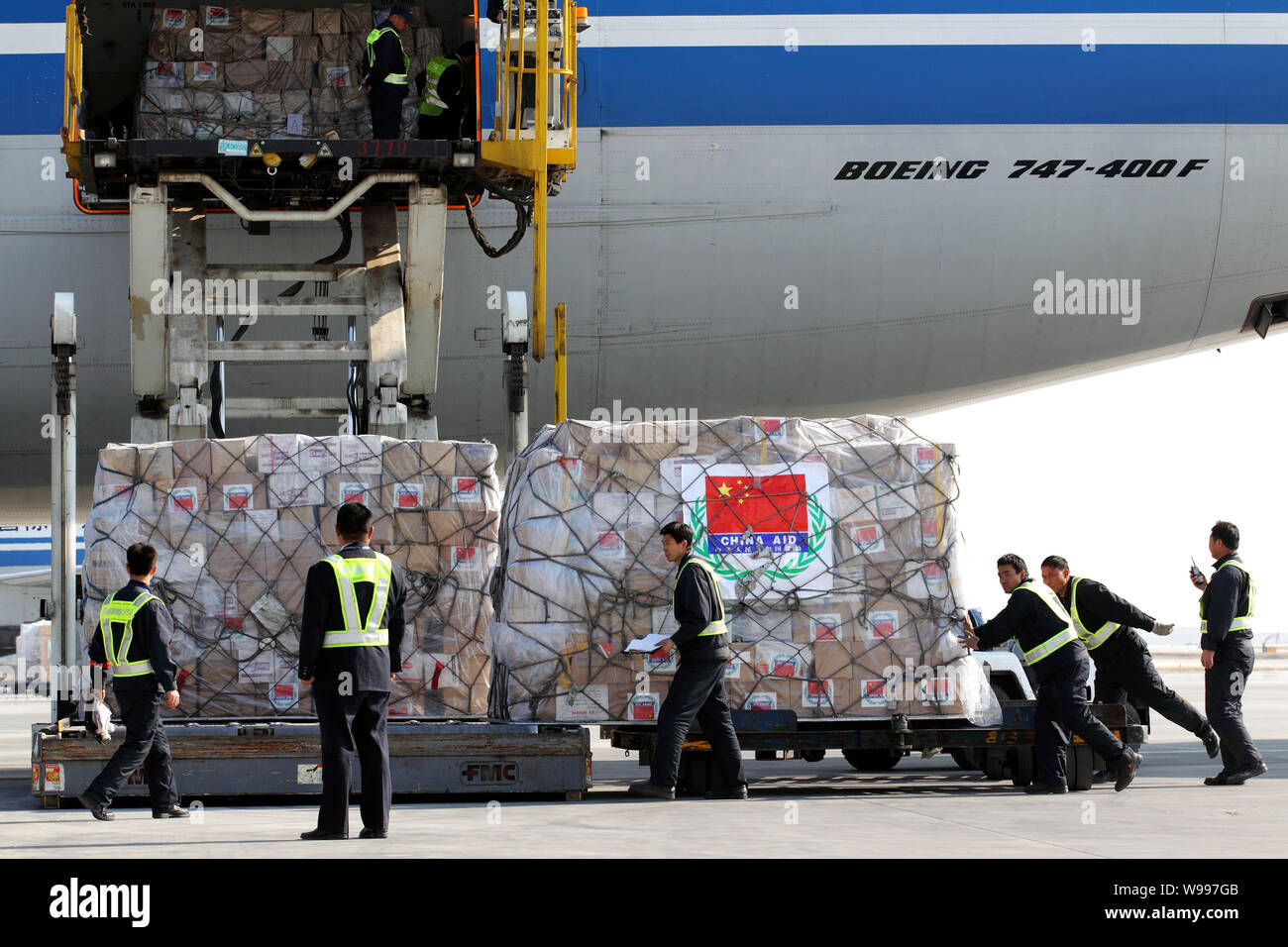Chinese ground staff load a plane with relief materials to Japan at the ...
