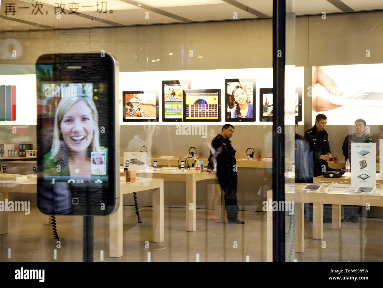 Chinese police officers investigate in an Apple Store whose operation ...