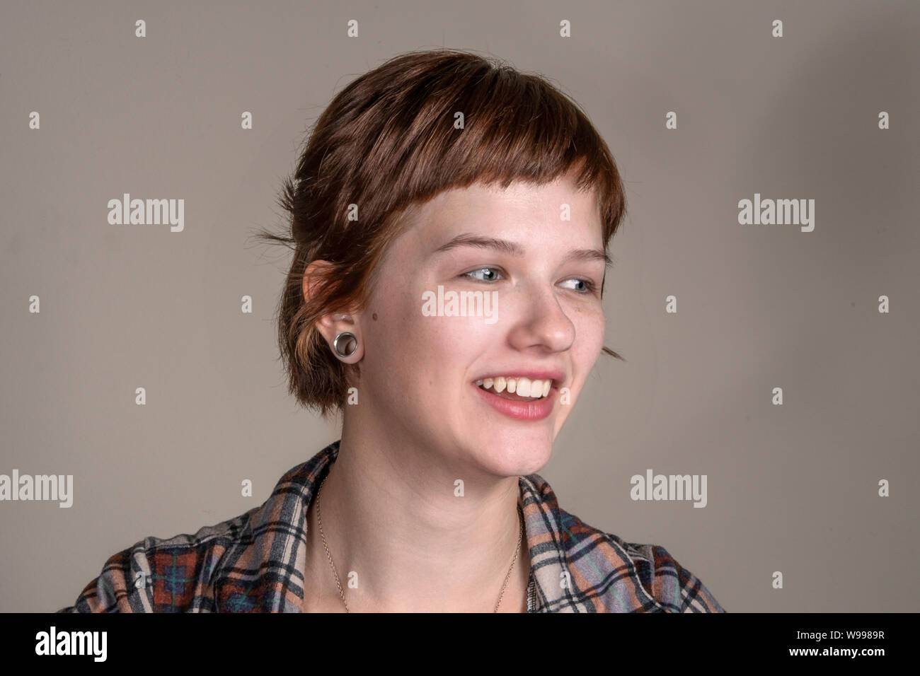 A pretty, young woman with a friendly, honest face smiles in a simple ...