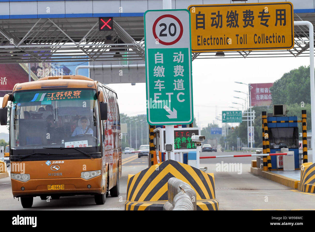 A bus passes through a toll station next to the ETC (Electronic Toll ...