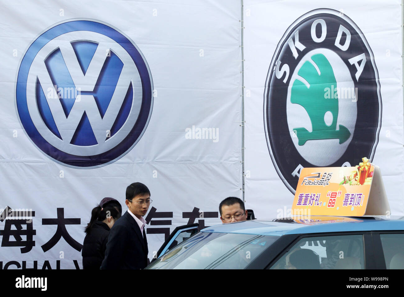 --FILE--Chinese visitors look at Volkswagen and Skoda cars of Shanghai ...
