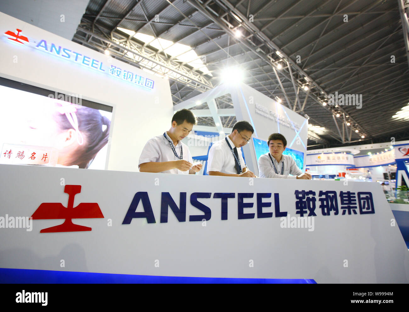 Chinese staff are seen at the stand of Anshan Iron & Steel Group during ...
