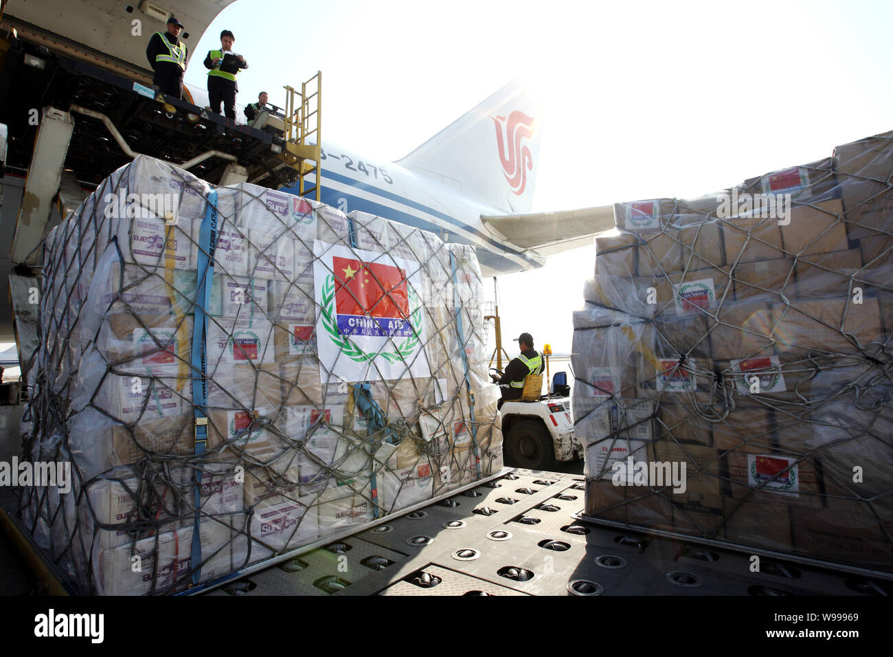 Chinese ground staff load a plane with relief materials to Japan at the ...
