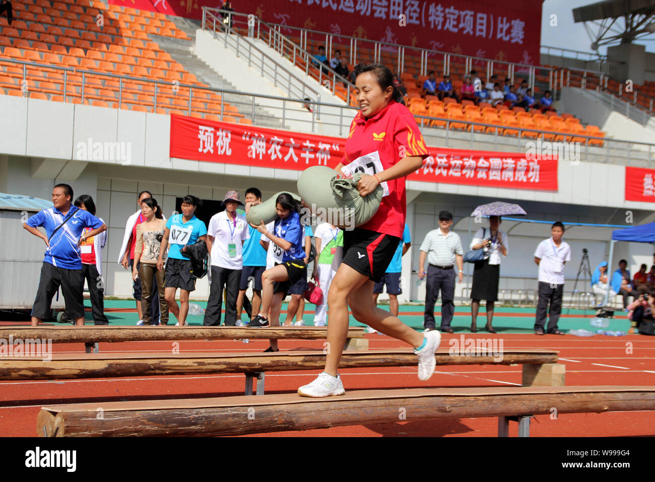Chinese farmers compete in the 60m food sacks race during the First ...