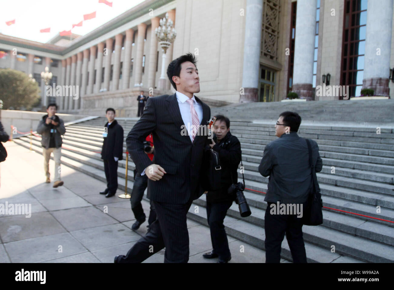 Chinese star hurdler Liu Xiang rushes to attend the opening ceremony of ...