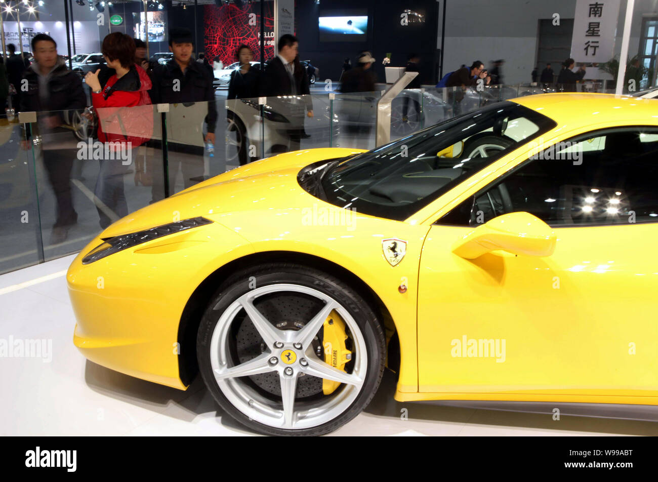 Visitors look at a Ferrari 458 Italia during the 2011 China Beijing ...