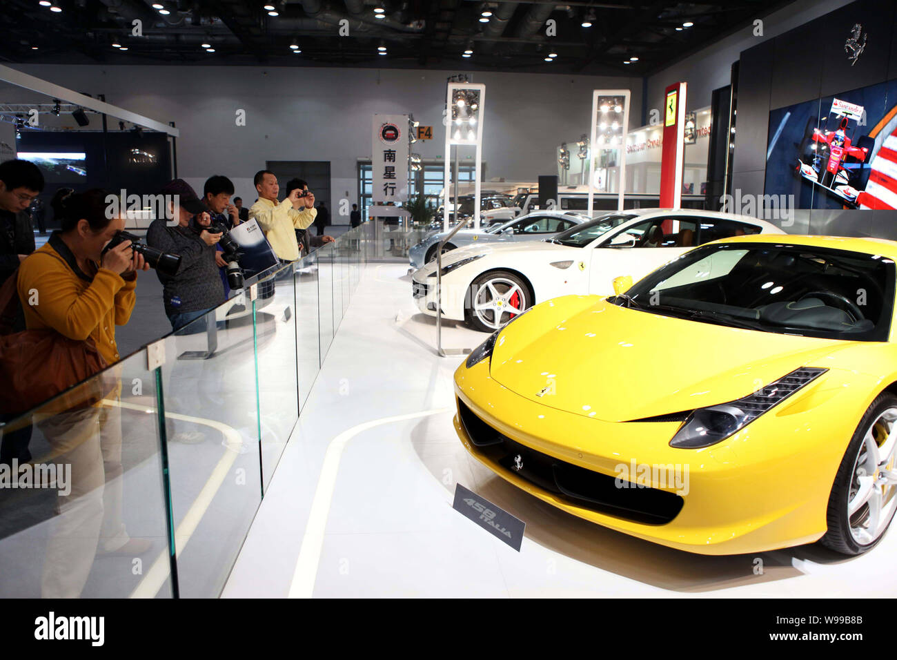 Visitors take photos of a Ferrari 458 Italia and other Ferrari cars ...