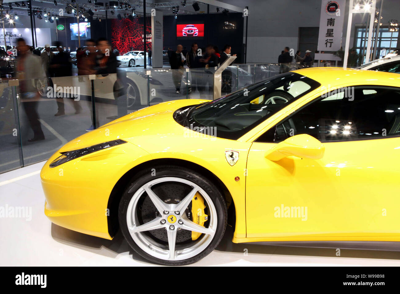Visitors look at a Ferrari 458 Italia during the 2011 China Beijing ...