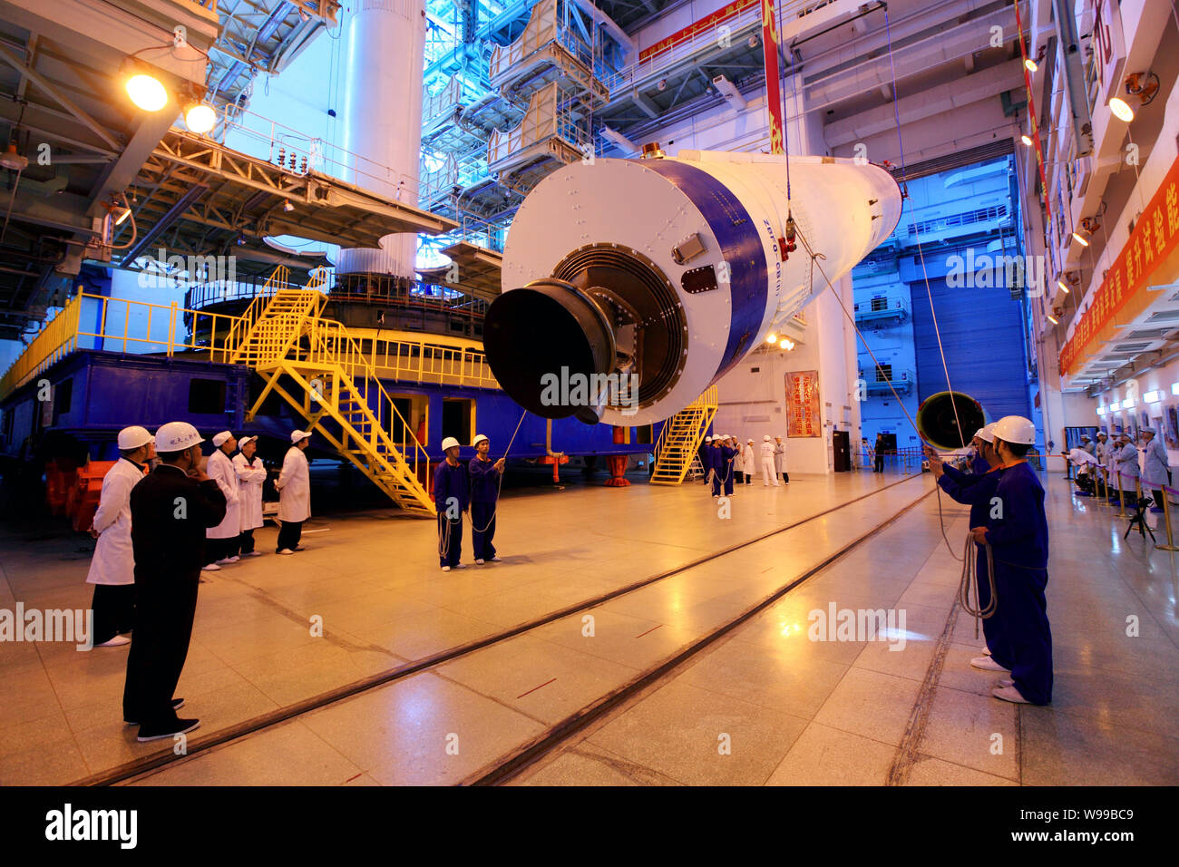 A booster is being hoisted to be fixed on a Long March 2F (CZ-2F ...