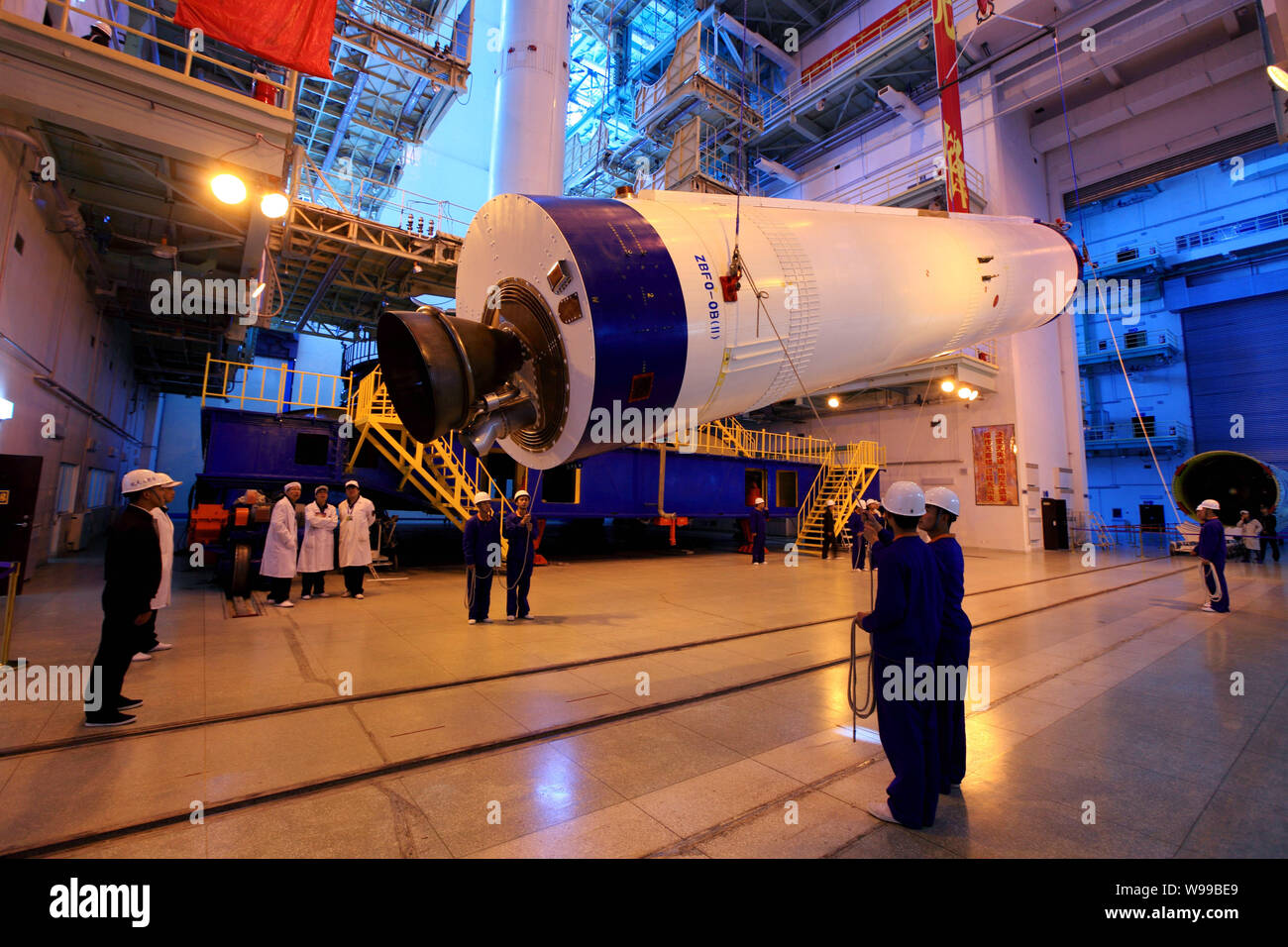 A booster is being hoisted to be fixed on a Long March 2F (CZ-2F ...