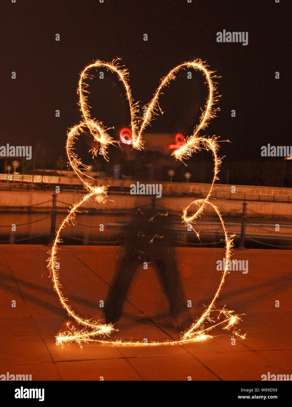 In this long exposure photo, a young man draws the shape of a rabbit ...