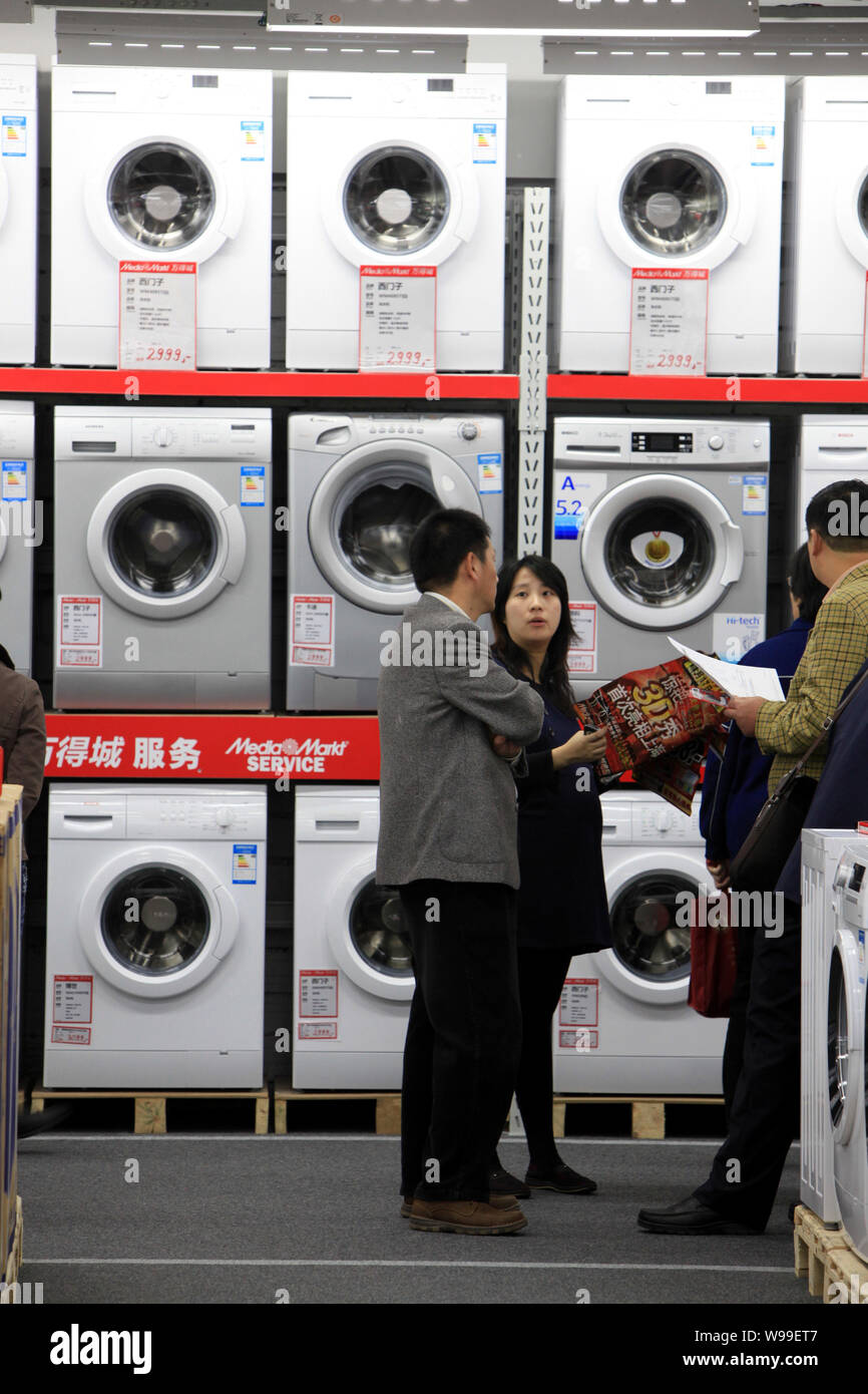 --FILE--Customers shop for cylinder washing machines at a Media Markt ...