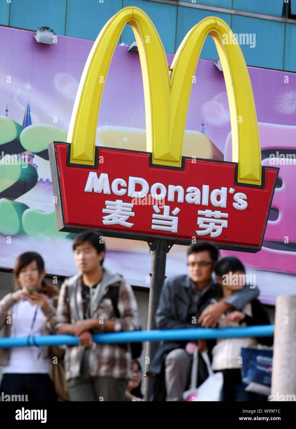 --FILE--Young people stand in front of a signage of McDonalds in ...
