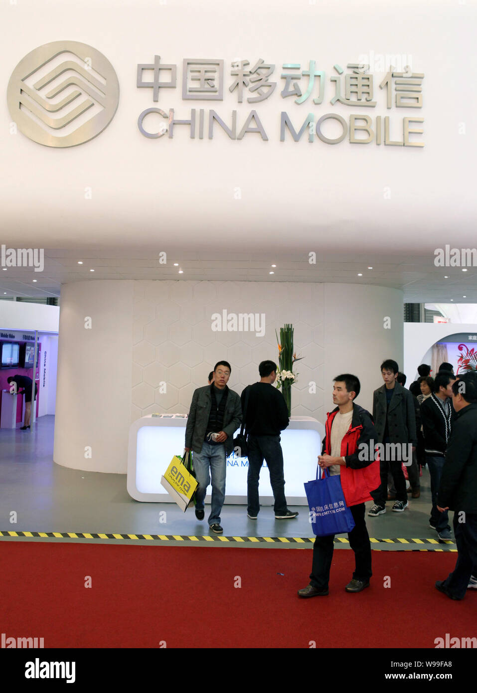 Visitors are seen at the stand of China Mobile during an exhibition in ...