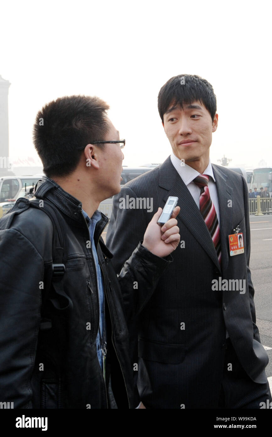 Chinese star hurdler Liu Xiang (right) is interviewed outside the Great ...