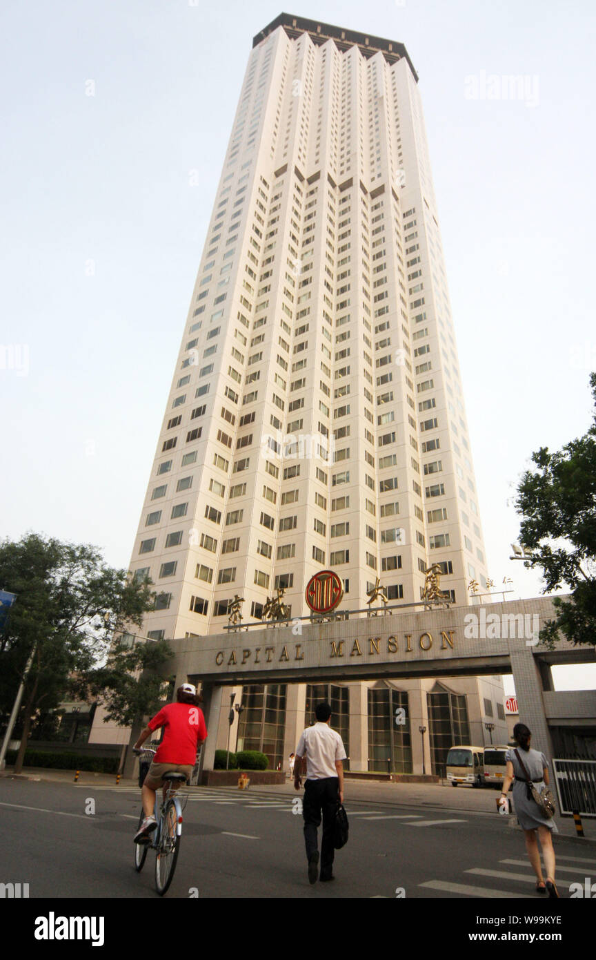--File--Local residents walk past the Capital Mansion, the headquarters ...