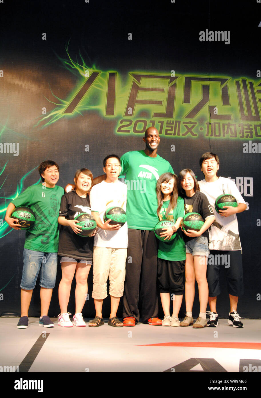 NBA star Kevin Garnett, center, poses with Chinese fans at a ...