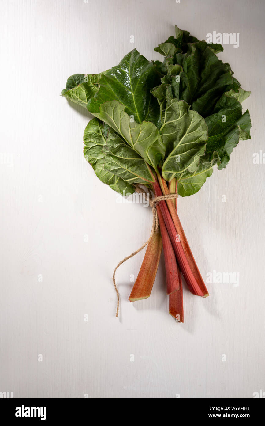 Bunch of fresh rhubarb top view on white wood Stock Photo - Alamy