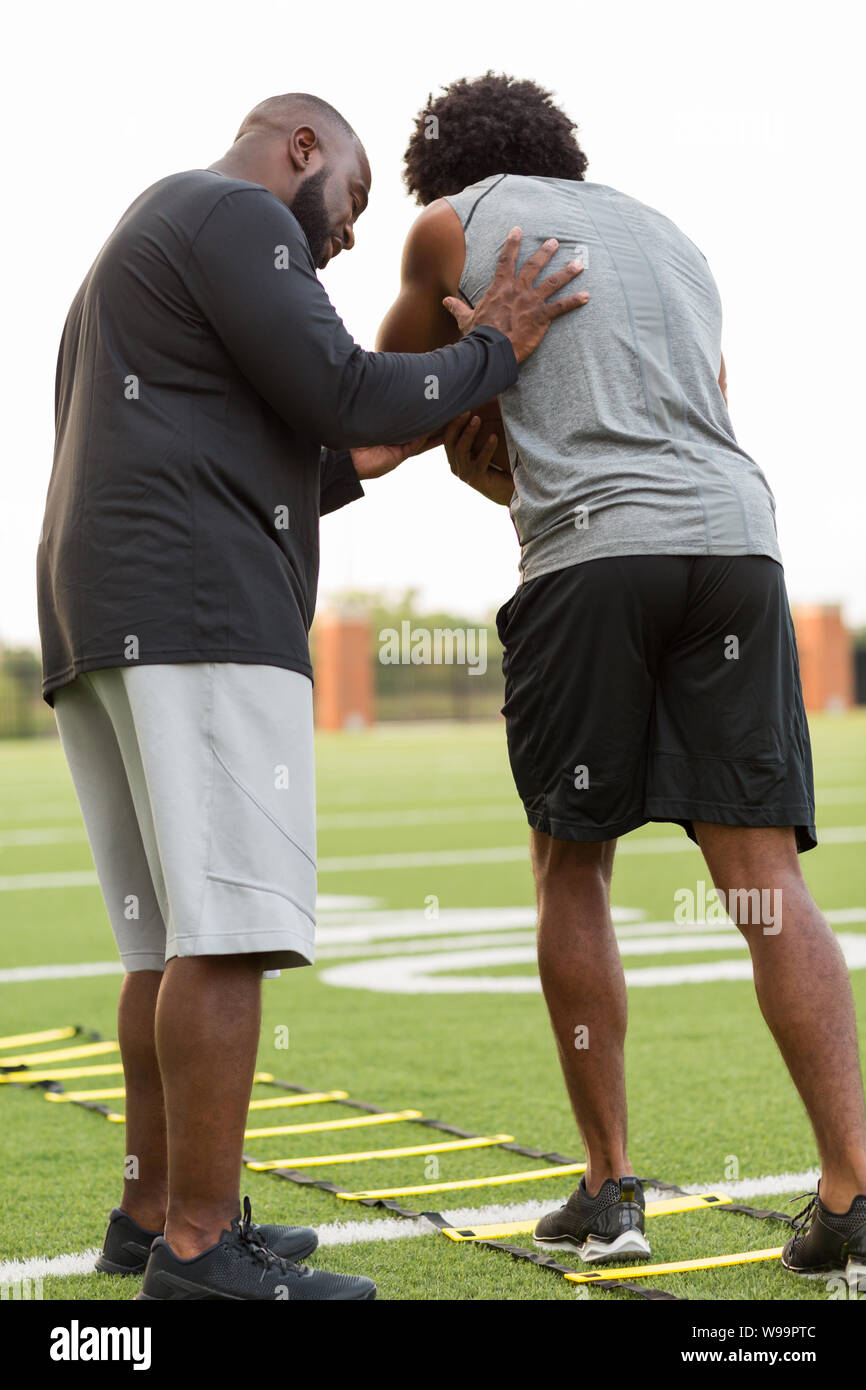 American Football coach training a young athlete Stock Photo - Alamy