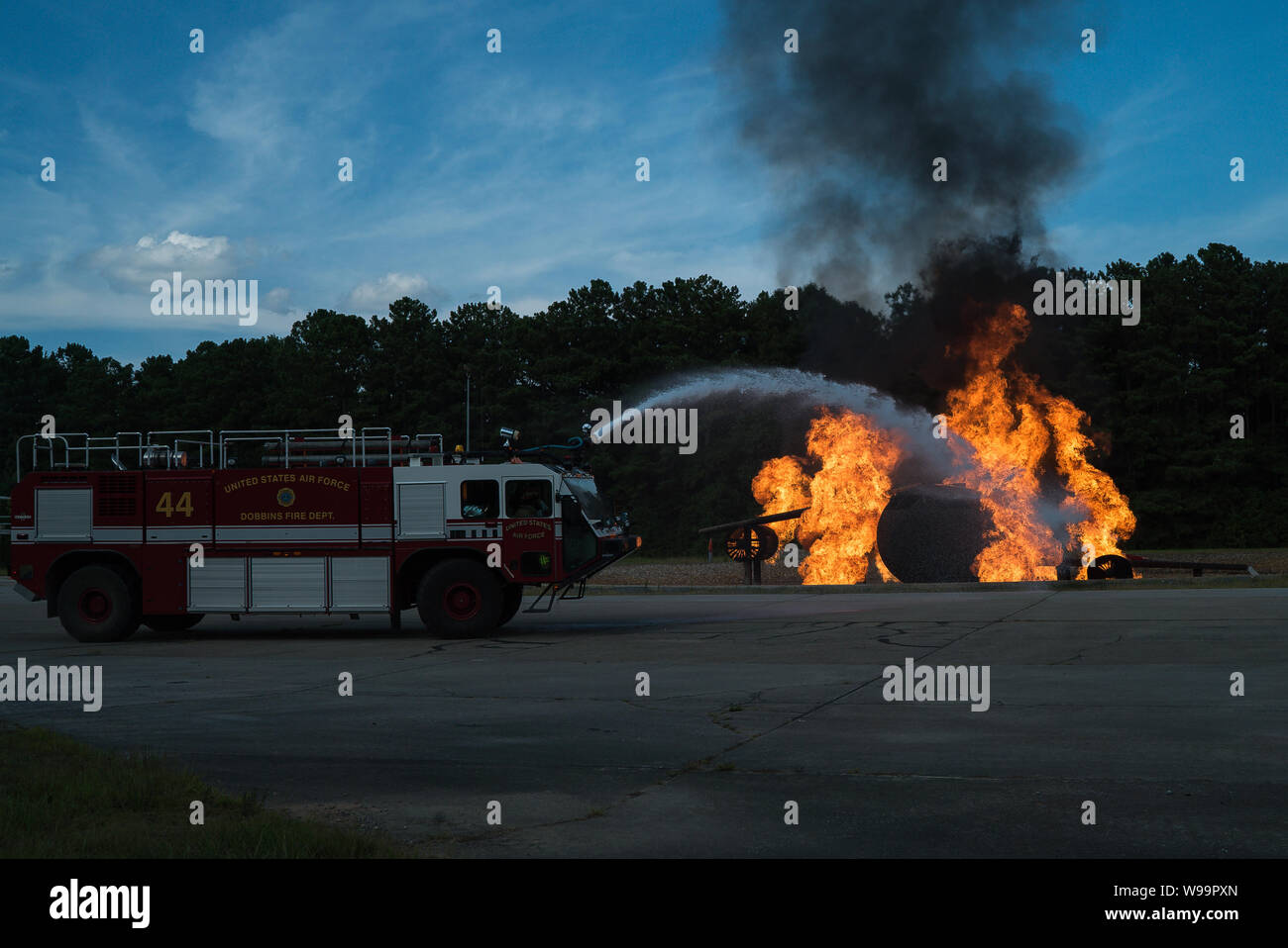 Firefighters extinguish a training fuselage engulfed in flames during ...