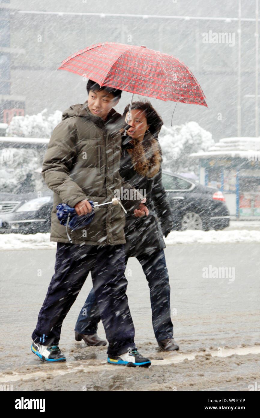 Local Chinese residents walk on the street in the heavy snow in ...