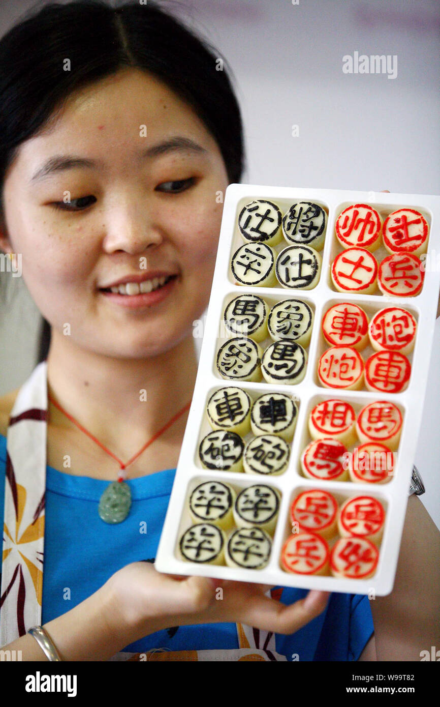 A Chinese customer shows chess pieces made from mooncakes at a bakery ...