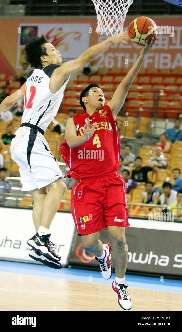 Kenta Hirose of Japan, left, tries to block a shot by Xaverius Prawiro of Indonesia in their ...