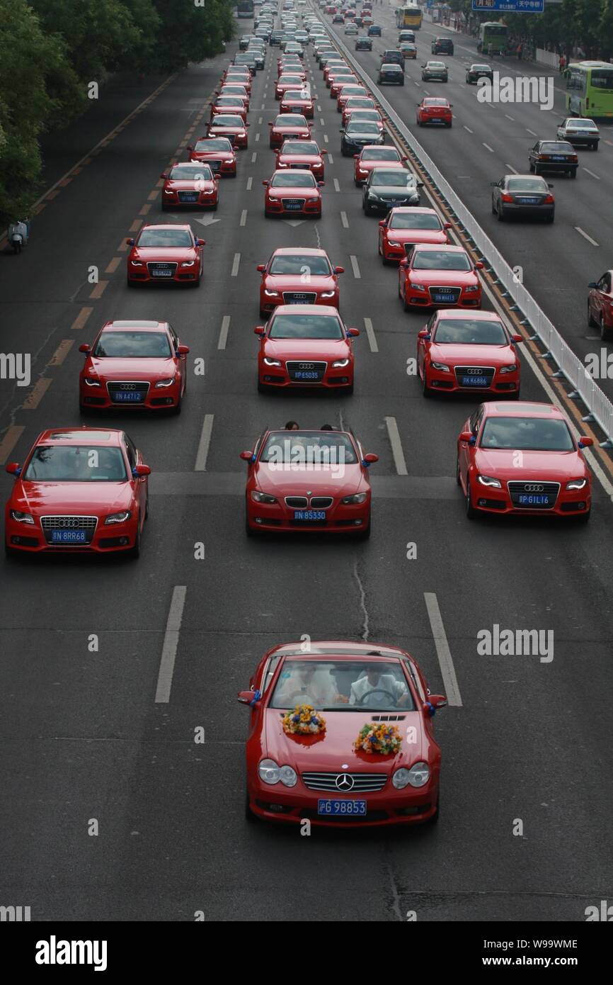 A flashy fleet of 35 red cars parade down Changan Avenue in Beijing ...