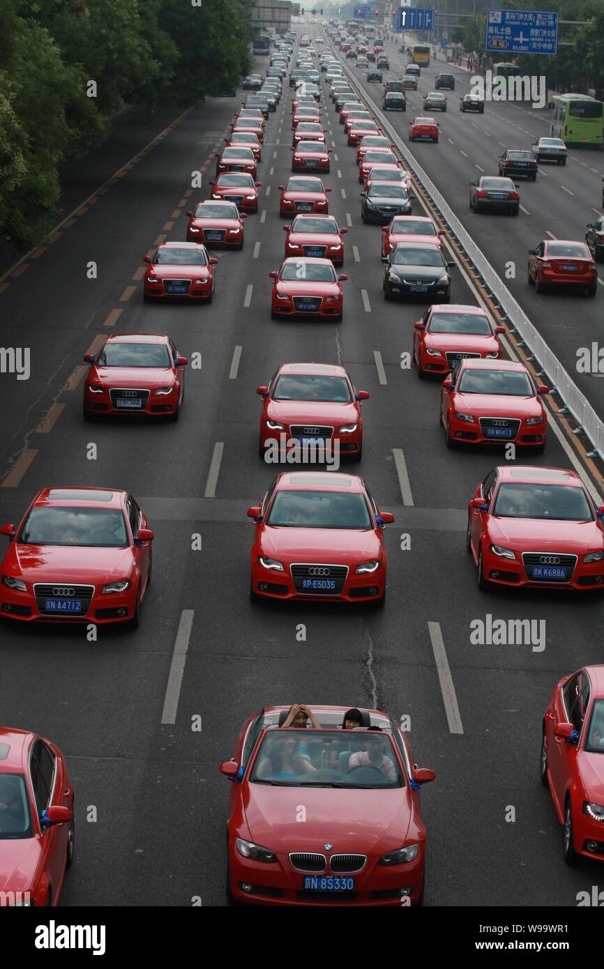 A flashy fleet of 35 red cars parade down Changan Avenue in Beijing ...