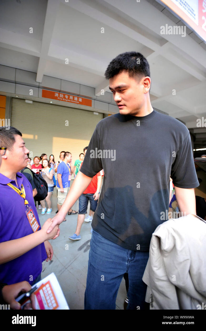Chinese basketball player Yao Ming (R) shakes hands with a receptionist ...