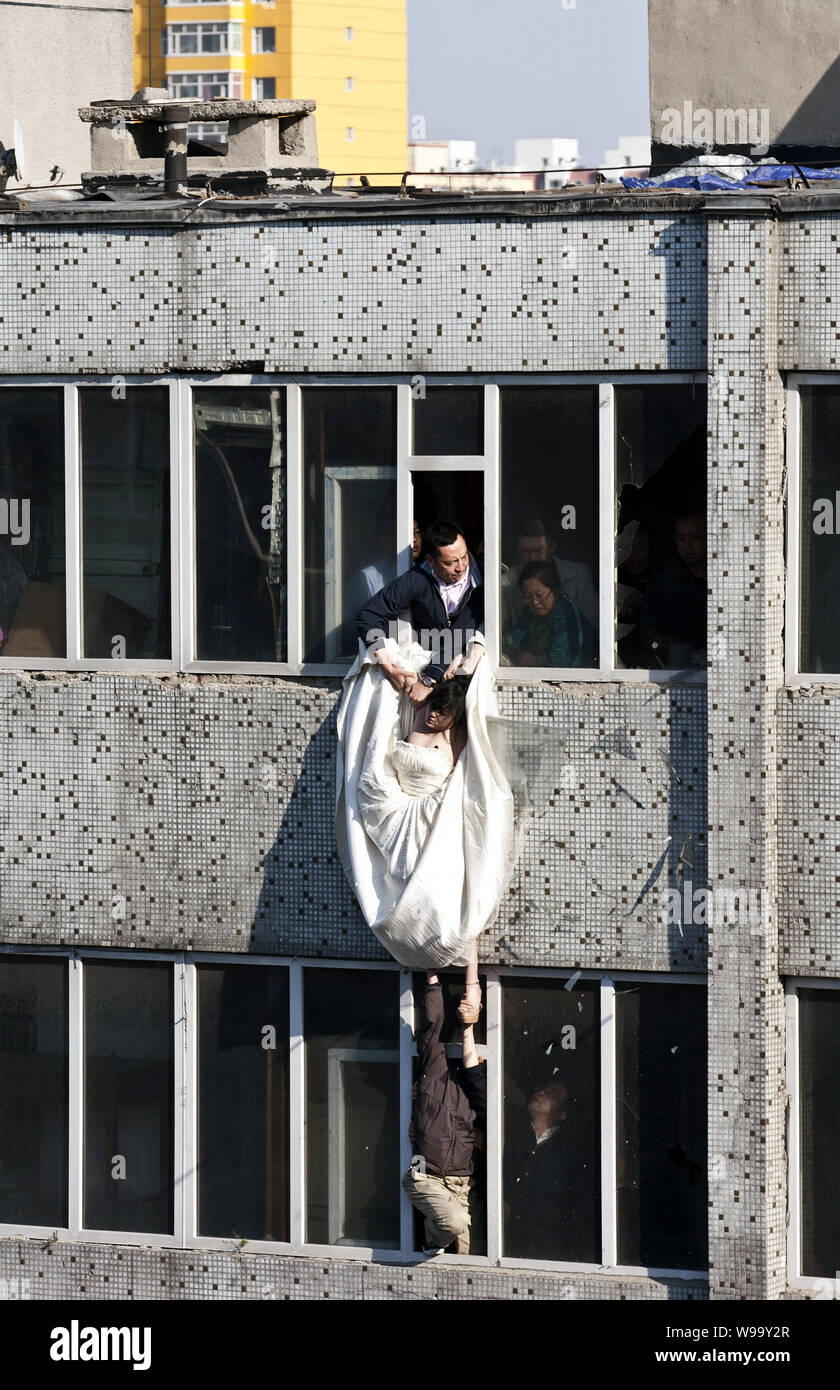 Rescuers try to pull the young woman dressed in her wedding gown who ...