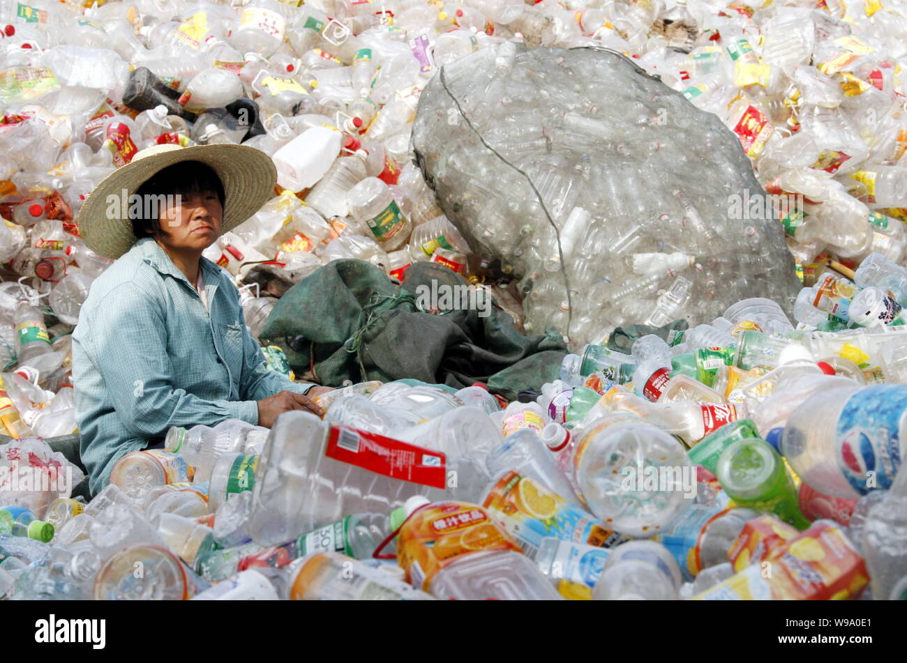 --FILE--A Chinese worker cleans up waste plastic bottles at a recycling ...