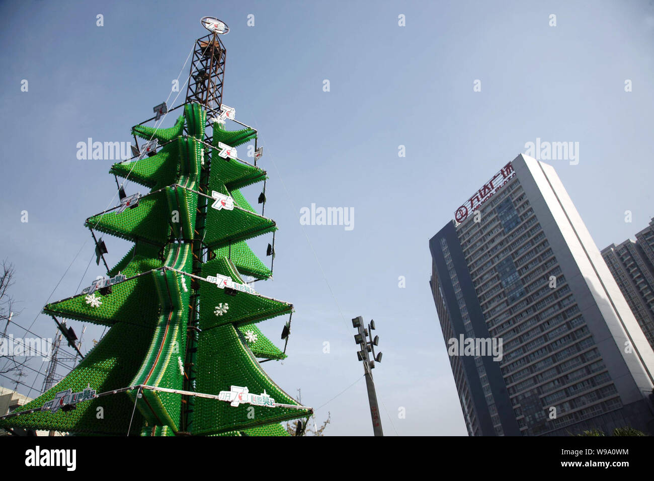 Chinese workers are building a Christmas tree consisting of beverage ...