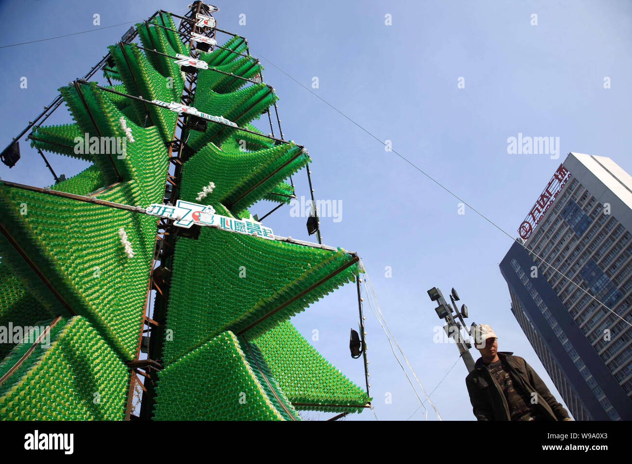 Chinese workers are building a Christmas tree consisting of beverage ...