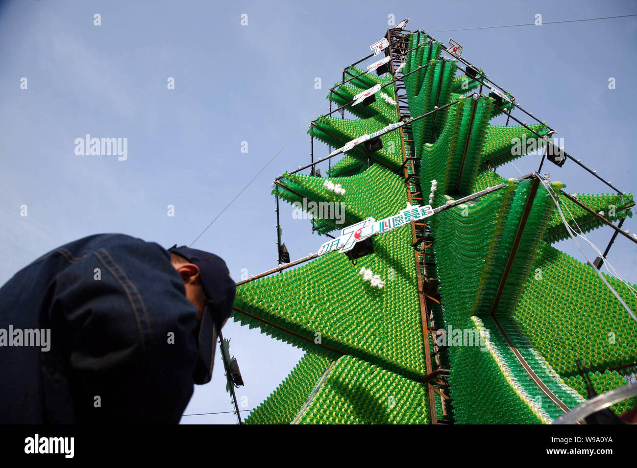 Chinese workers are building a Christmas tree consisting of beverage ...