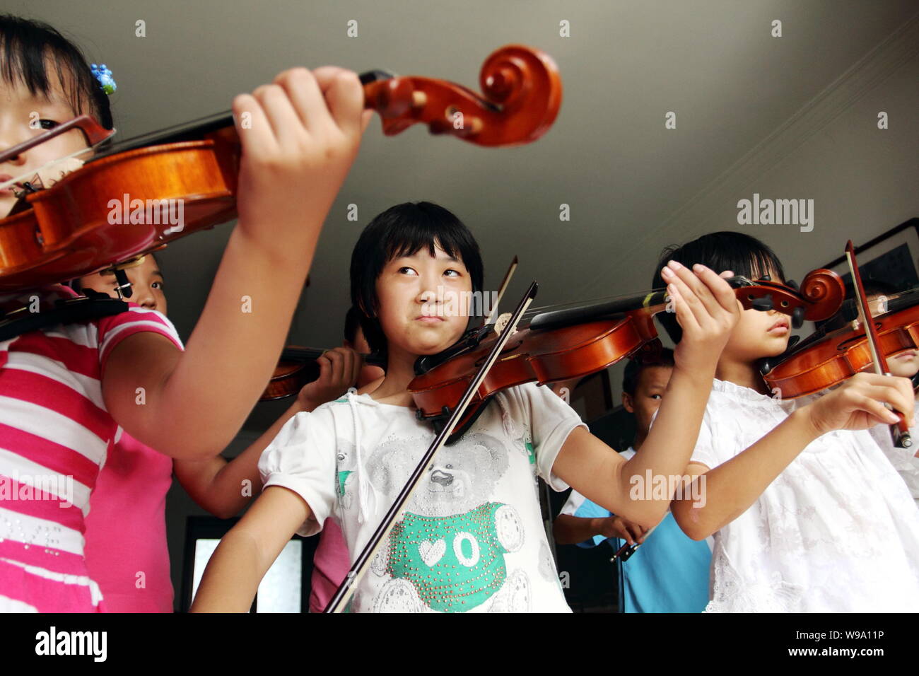 Chinese kids playing musical instrument hi-res stock photography and ...