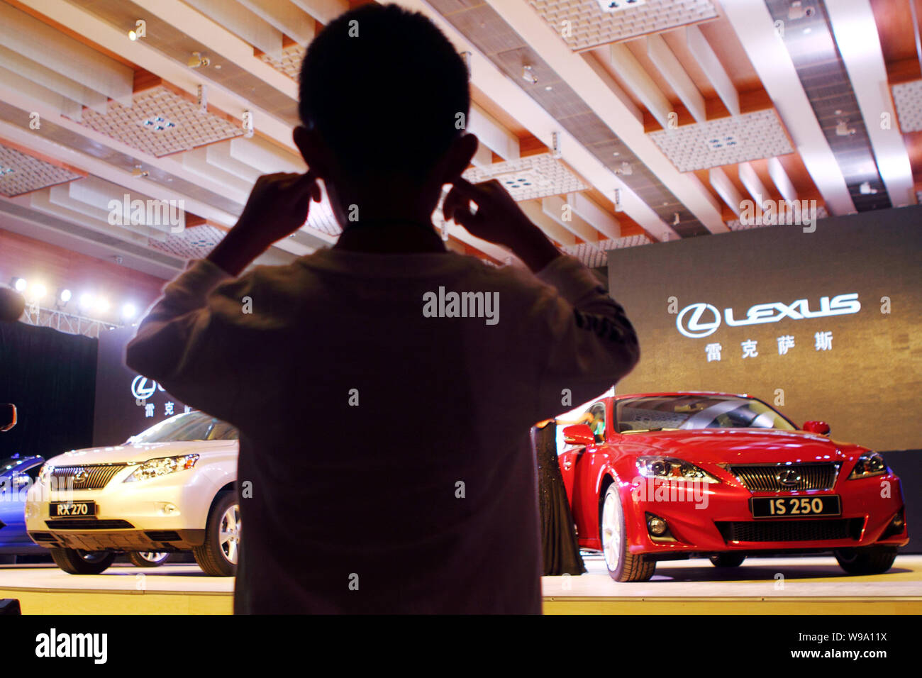 --FILE--A Chinese kid looks at Lexus IS250 and RX270 during a launch ...
