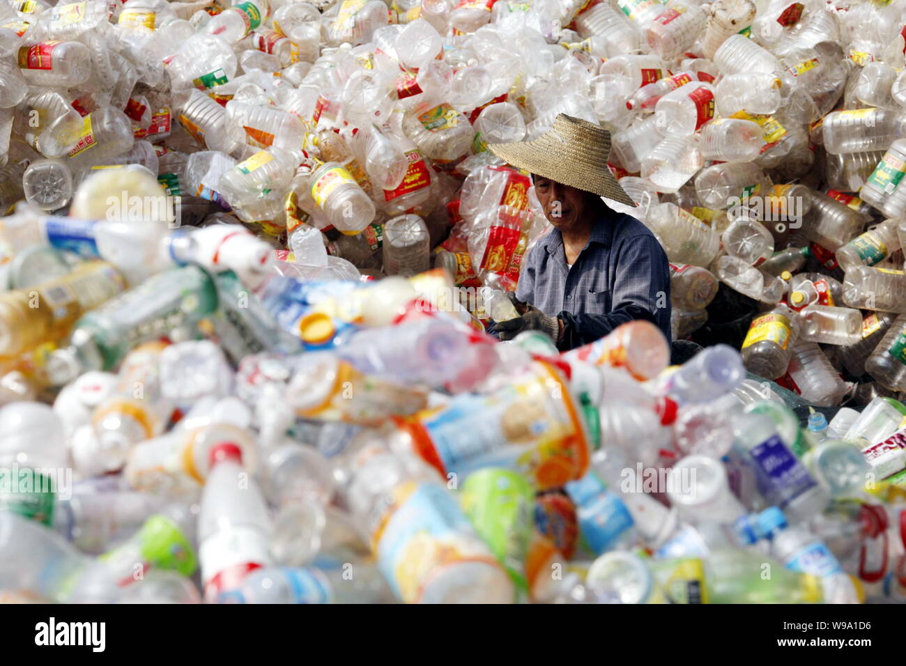 --FILE--A Chinese worker cleans up waste plastic bottles at a recycling ...
