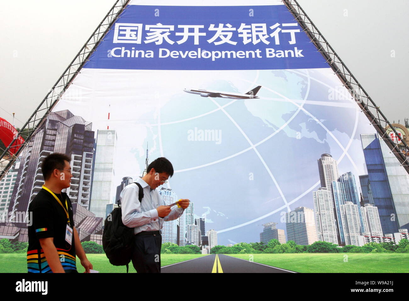 --FILE--Chinese visitors walk past an advertisement for China ...