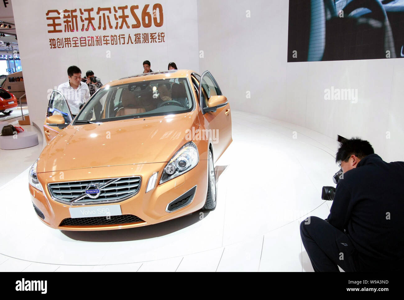 Chinese car buyers look at a Volvo S60 during an auto show in Beijing ...