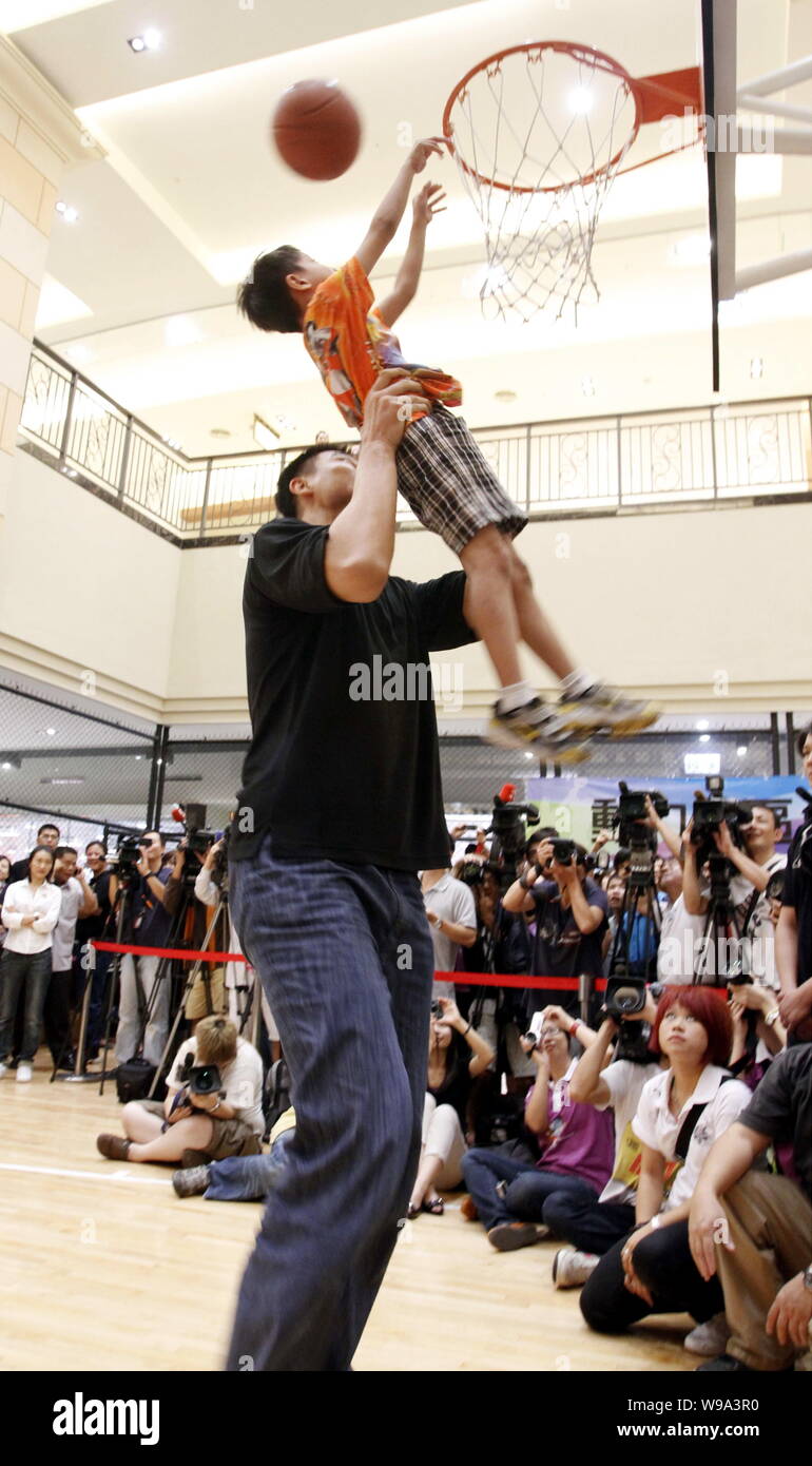 Chinese basketball player Yao Ming lifts a Taiwanese kid to help him ...