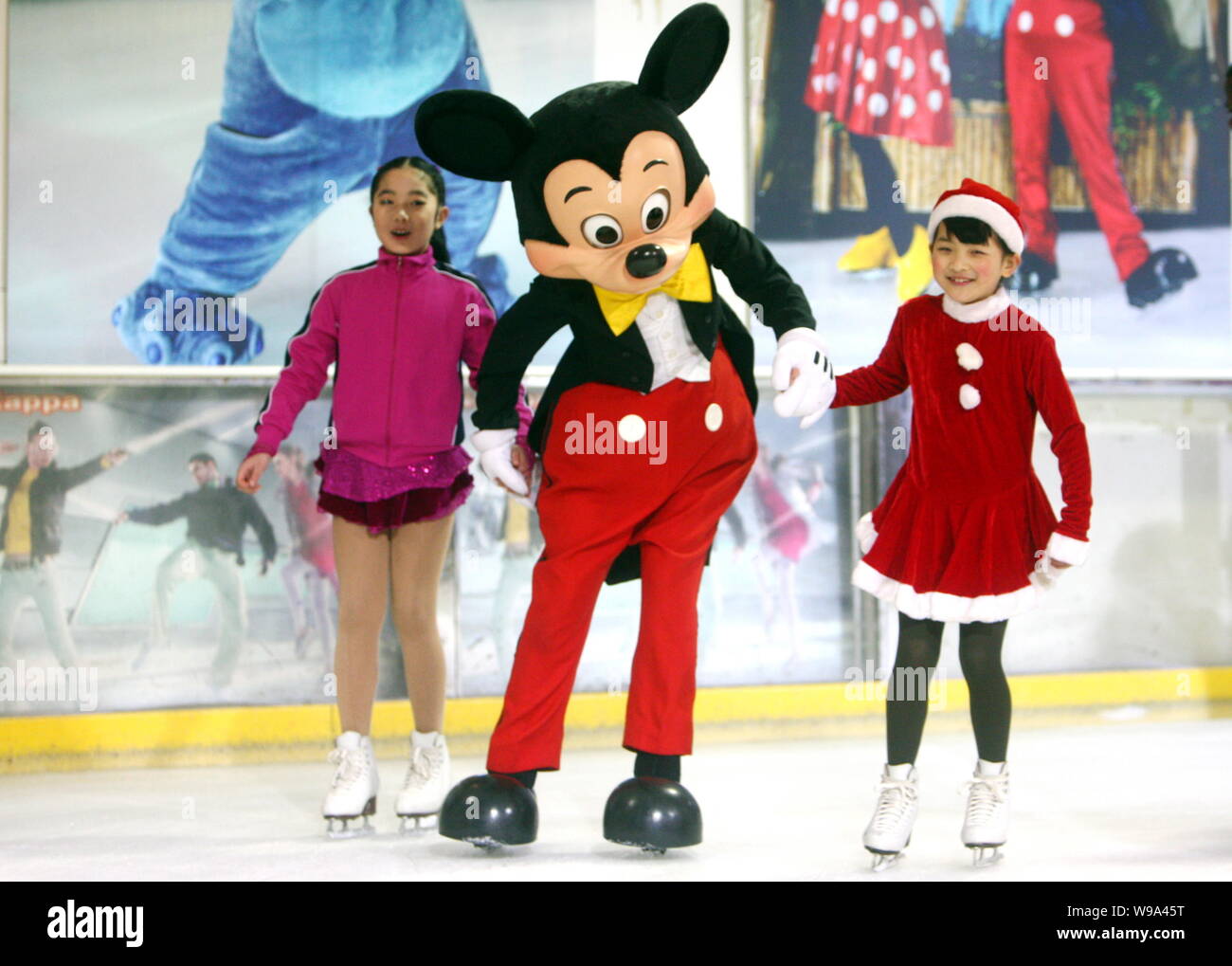 Mickey Mouse skates with two young girls at a press conference for the ...