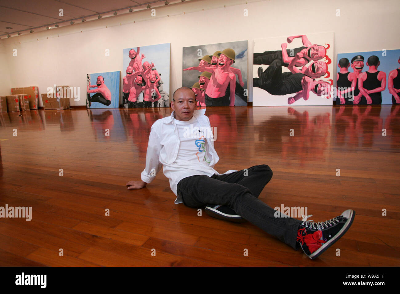 Chinese artist Yue Minjun prepares paintings for his art exhibition in ...