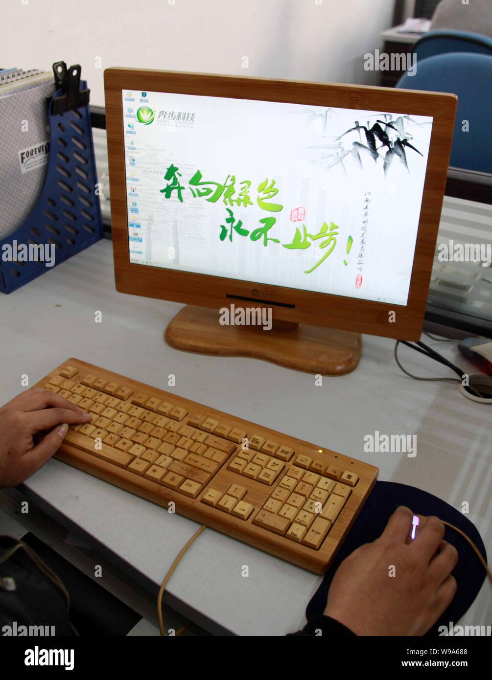 A Chinese employee uses bamboo-made computer keyboard and mouse in ...