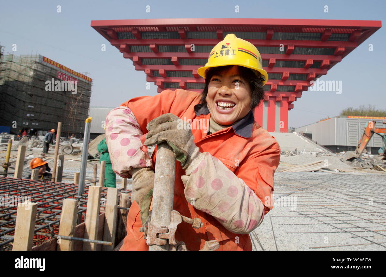 Chinese construction workers labor in front of the China Pavilion in ...