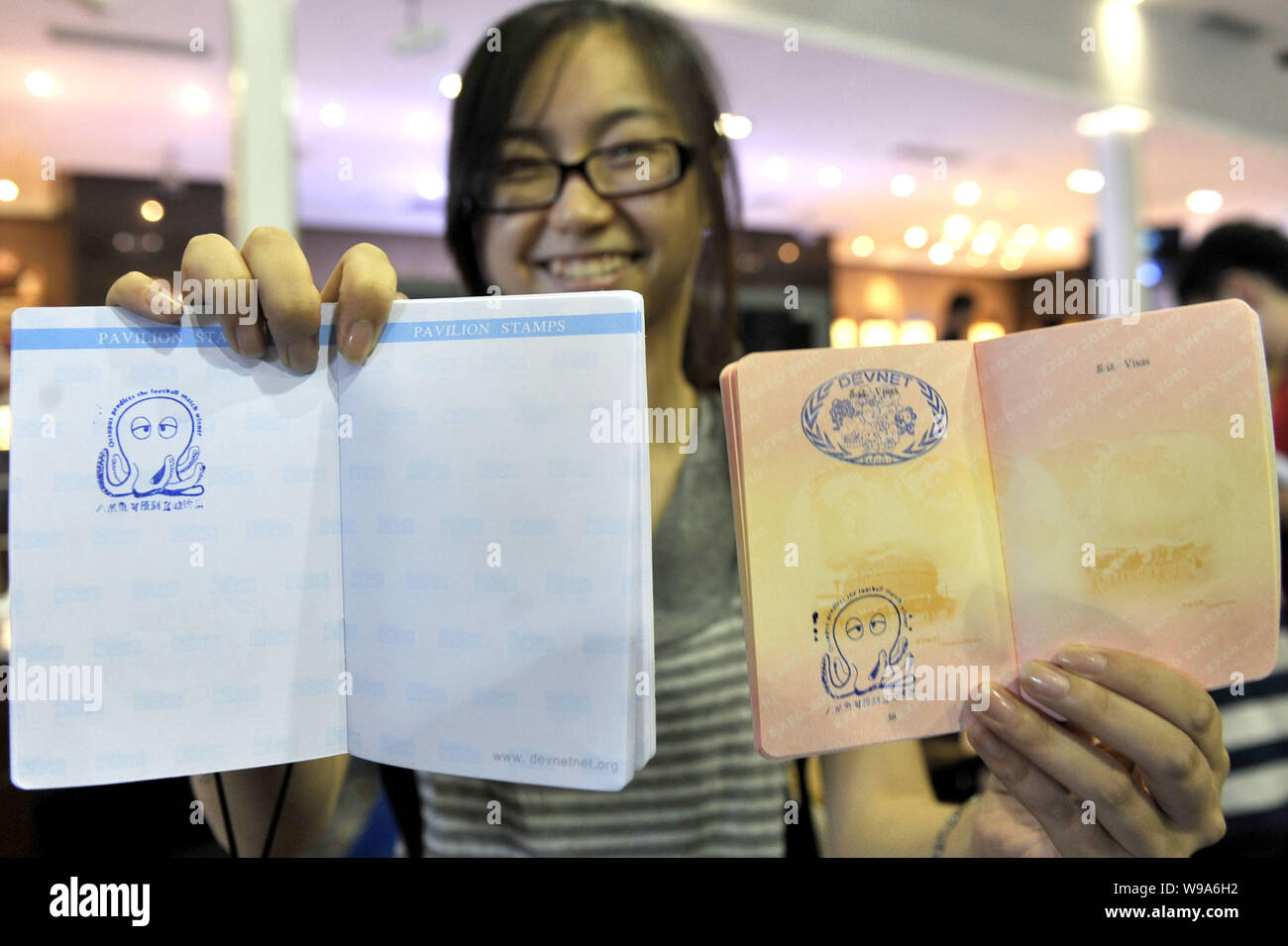 A Chinese woman shows Expo passports stamped with the octopus lucky seals at the DEVNET ...