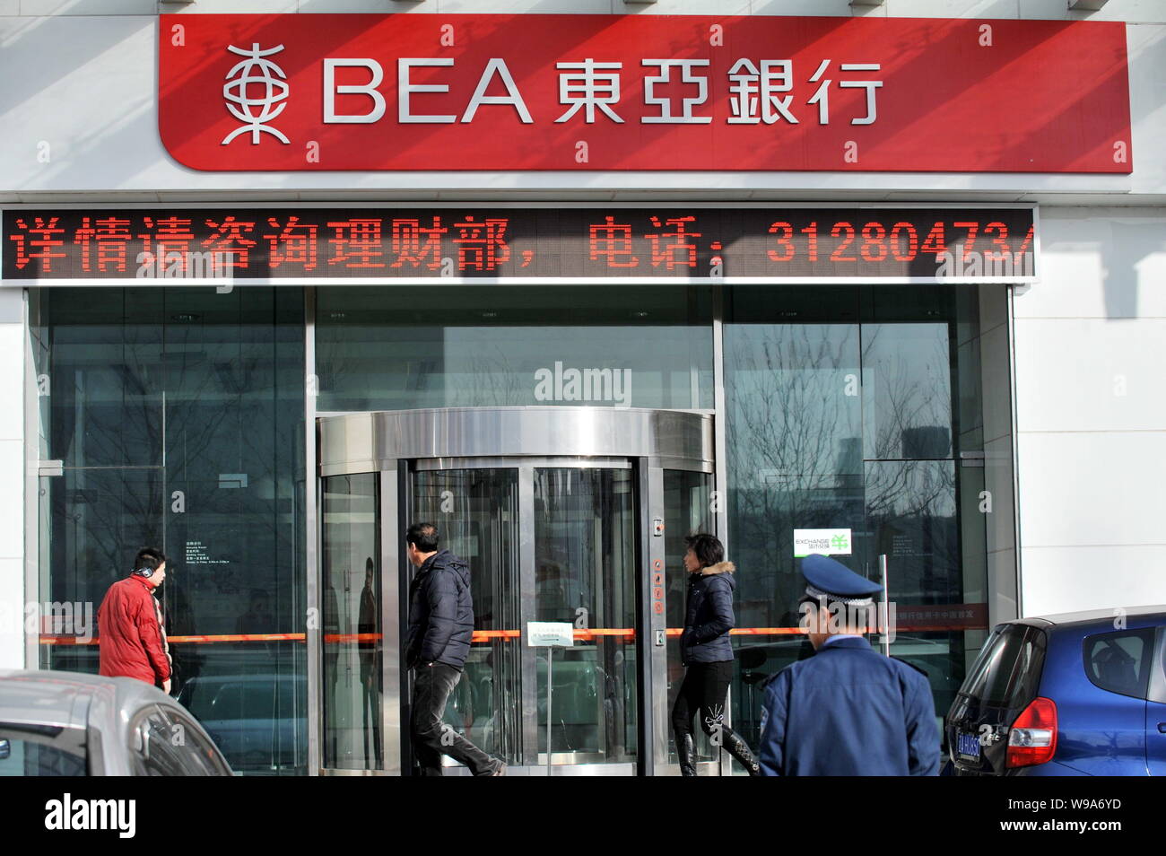 --FILE--Local Chinese residents walk past a branch of BEA (Bank of East ...