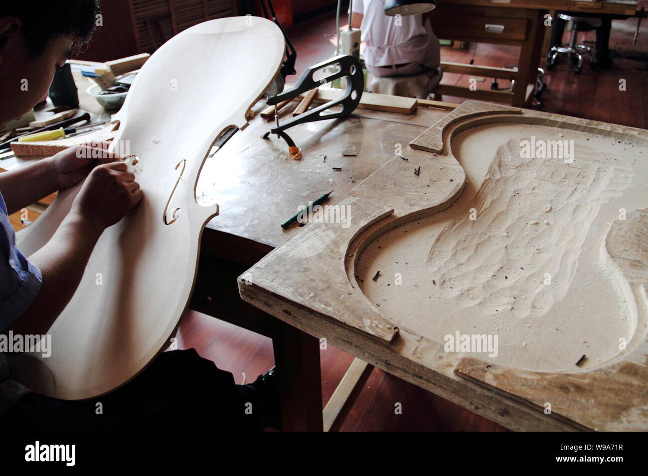 A Chinese worker makes a violin in the factory of Beijing Huadong ...
