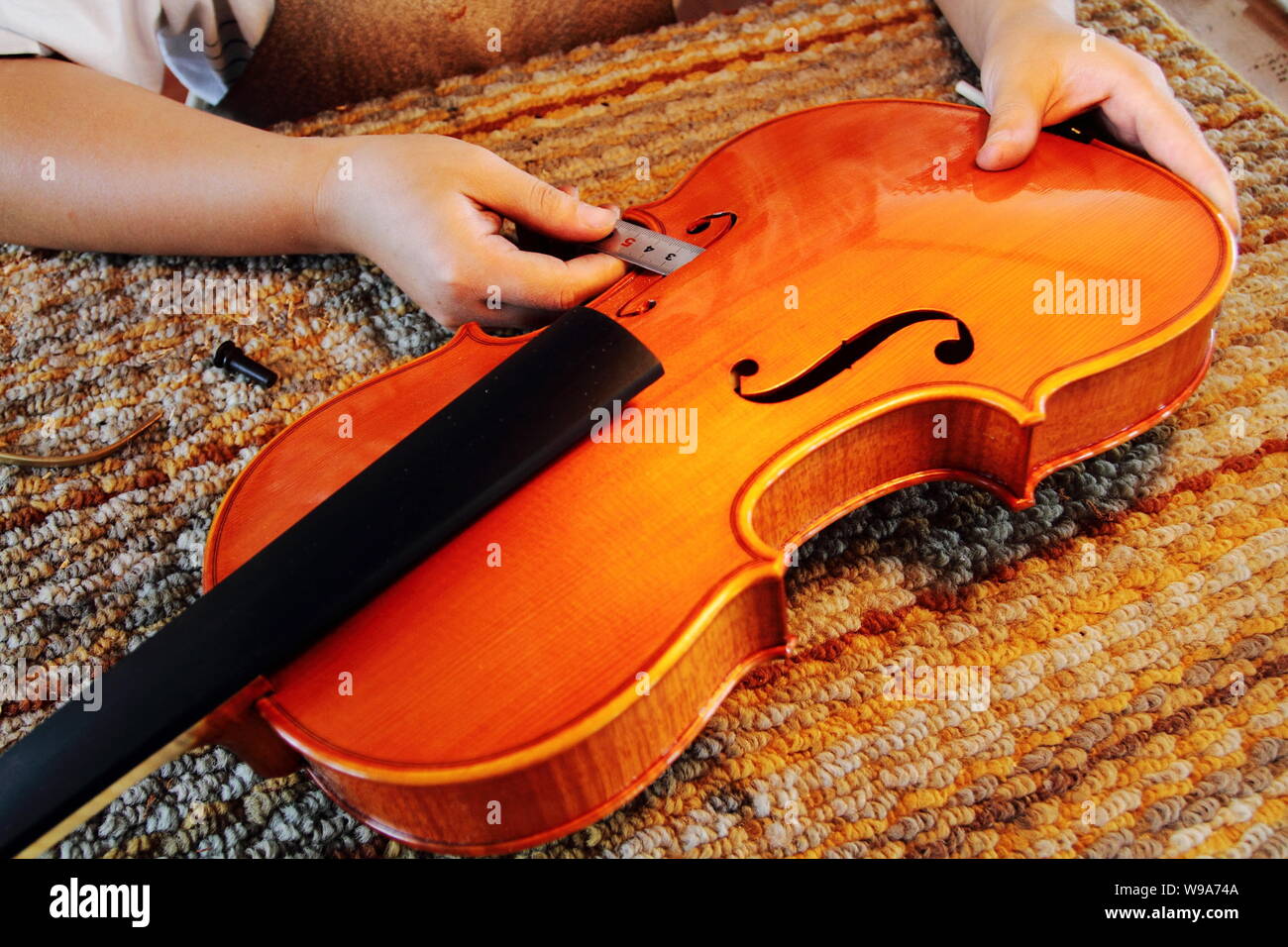 A Chinese worker makes a violin in the factory of Beijing Huadong ...