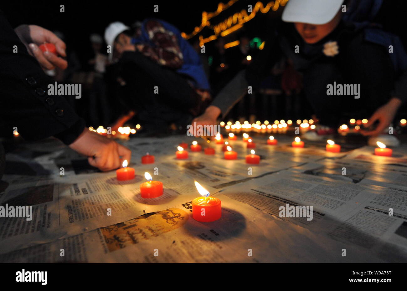 Local Chinese residents light up candles to mourn for the victims of ...